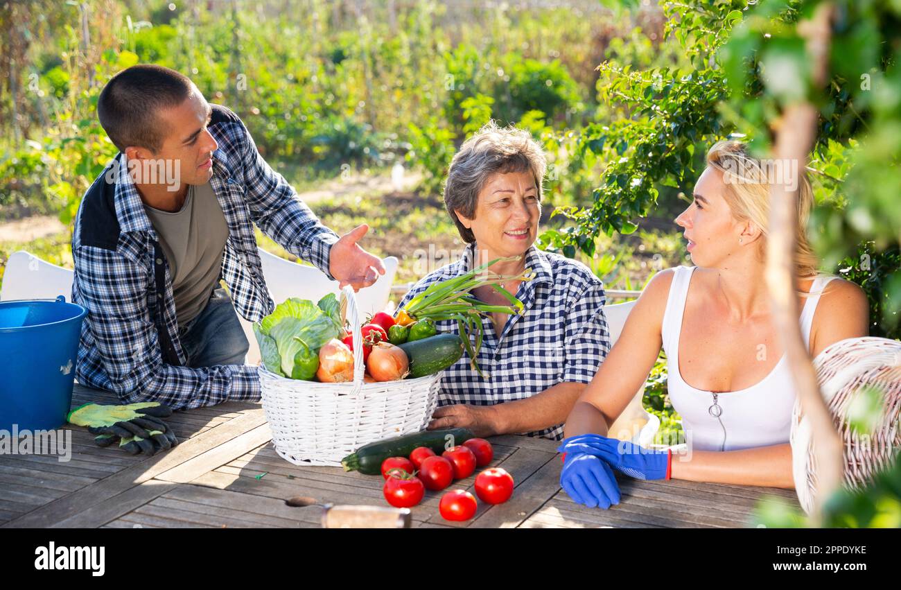 Happy family with ripe vegetables harvest in garden Stock Photo - Alamy