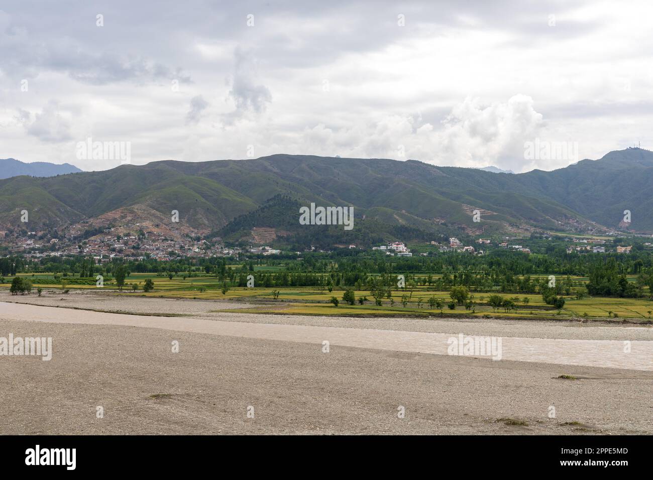 Beautiful scenery of a green wheat fields across a river in the ...