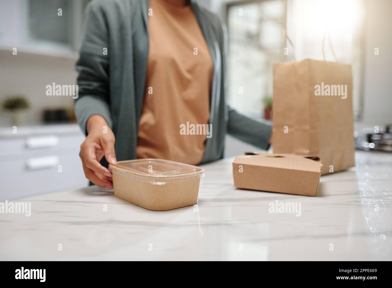 Woman taking containers with dishes out of paper package Stock Photo ...