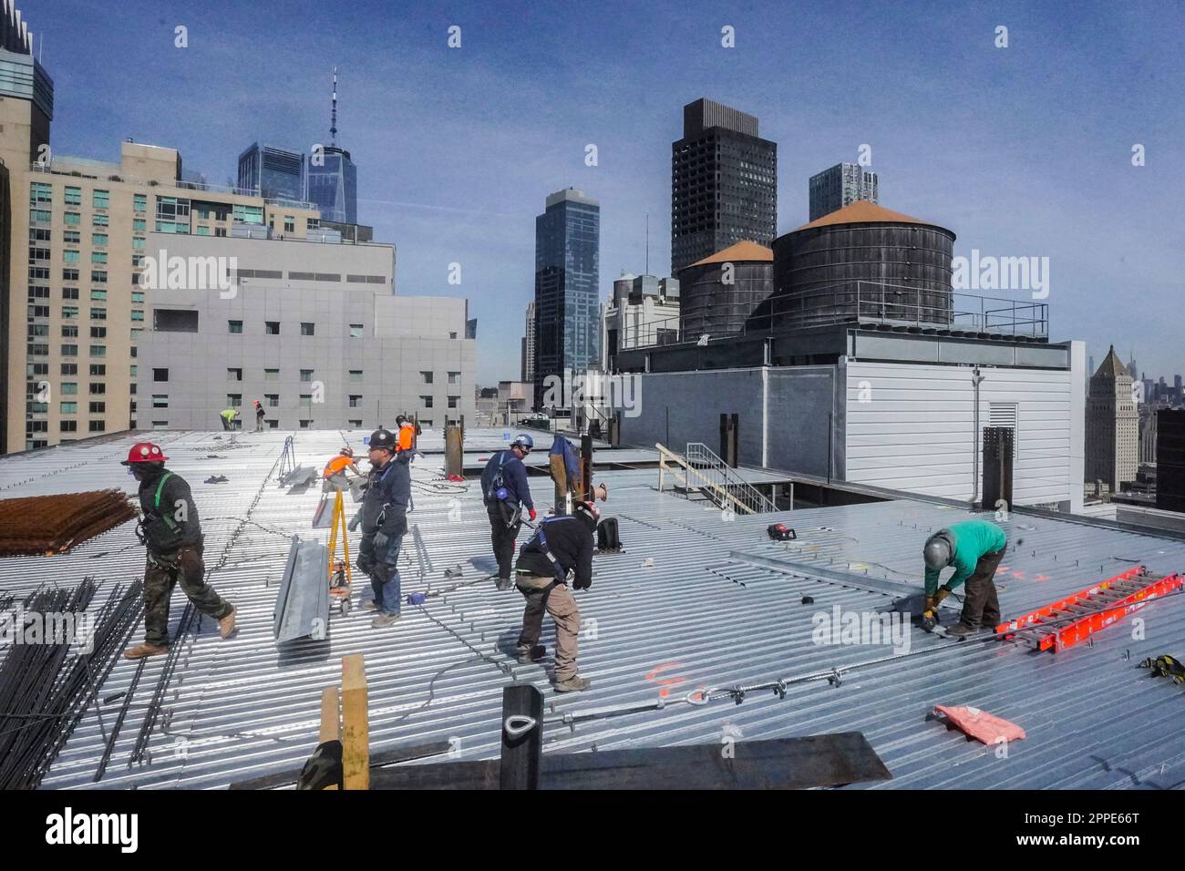 Construction workers update the roofing on a high rise at 160 Water ...