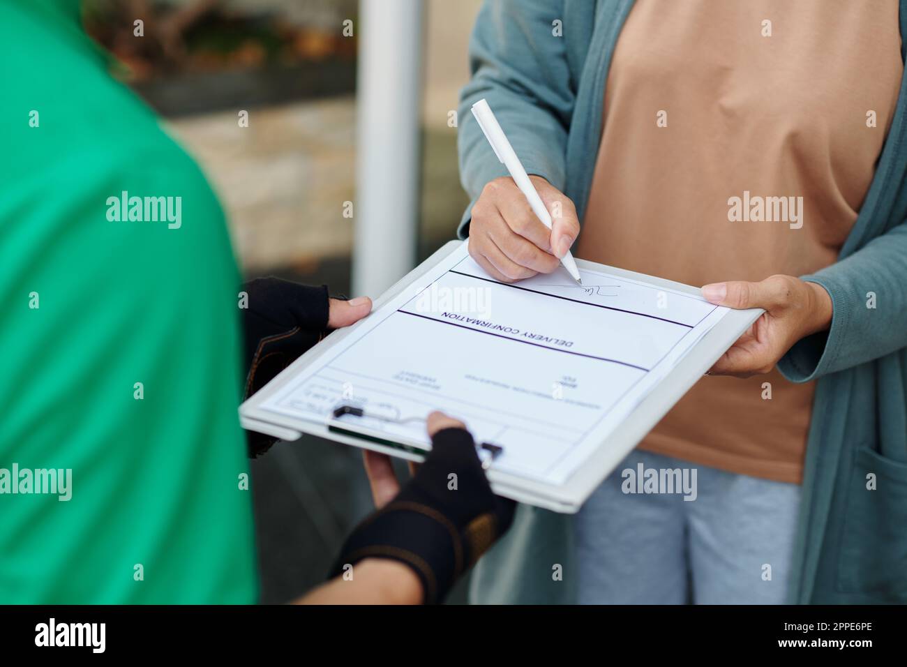 Customer signing document after receving delivery Stock Photo - Alamy