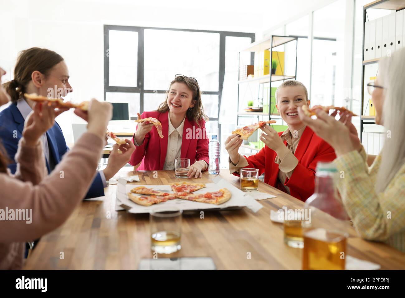 Happy company staff enjoys fastfood at pizza party in office Stock ...