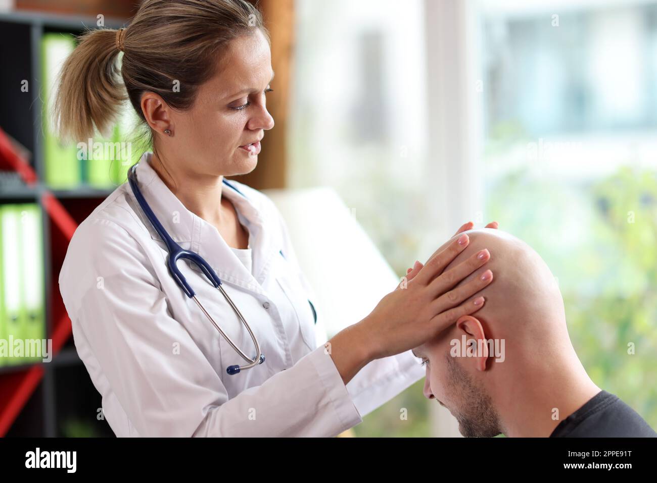 Lady dermatologist examines head skin of bald man in clinic Stock Photo ...