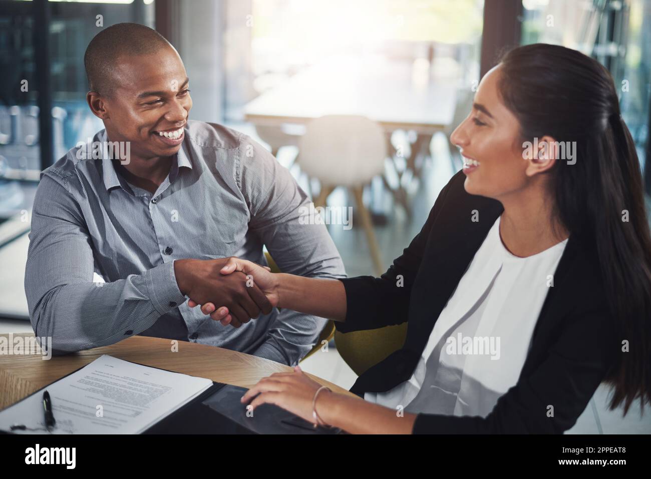 Our talents would be better merged together. two businesspeople shaking ...