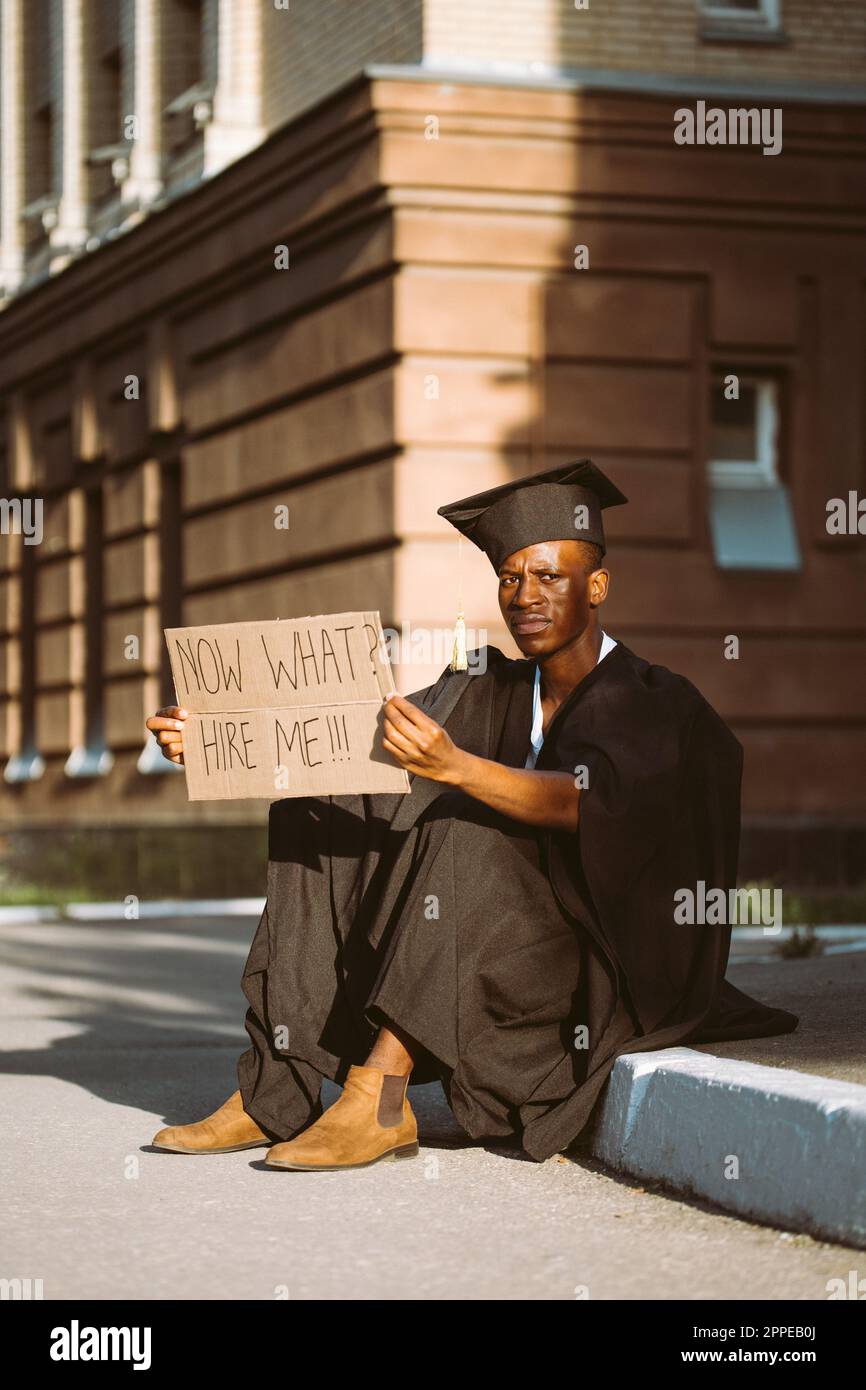 Happy black guy sitting with cardboard poster on street looking for job ...