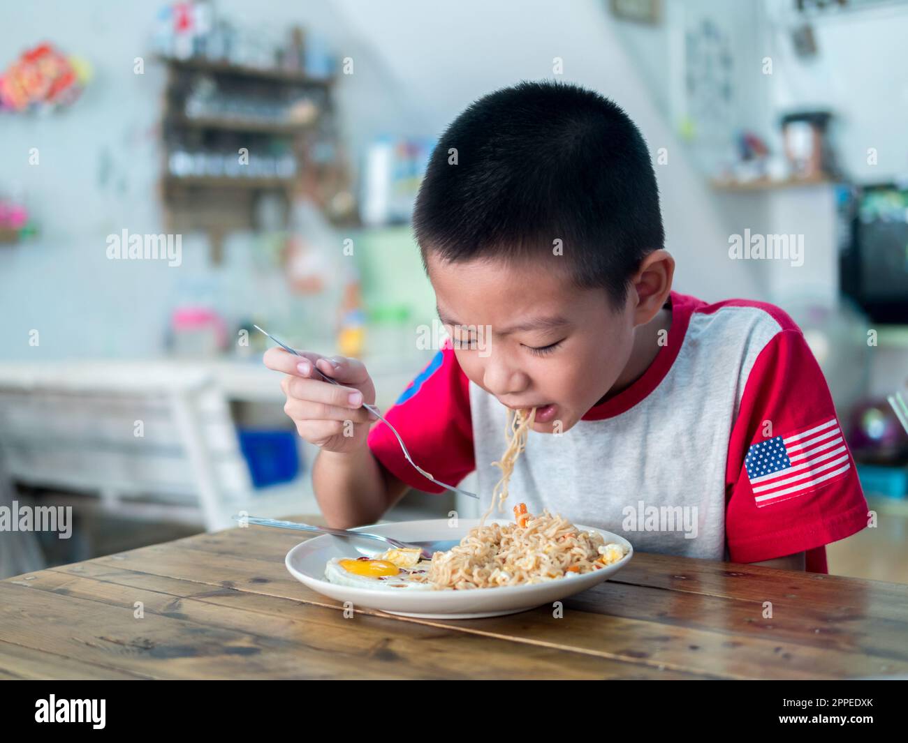 Happy Asian boy eating delicious noodle Stock Photo - Alamy