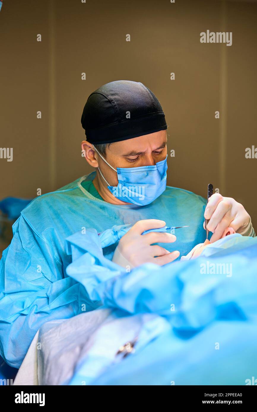 plastic surgeon operates on a patient in the operating room Stock Photo ...