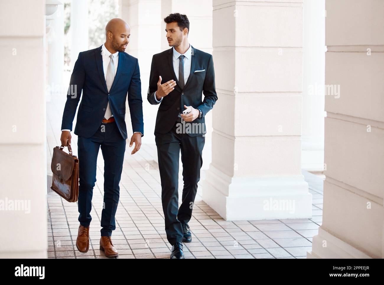 Travelling to work together. young handsome businessmen talking outside ...