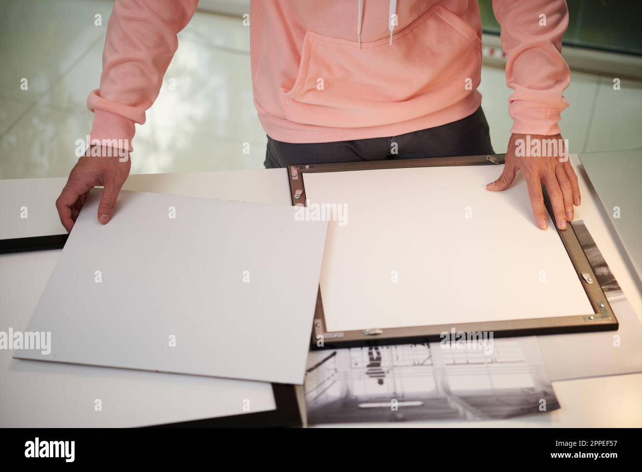 Exhibition curator preparing for event, putting photos in frames Stock ...