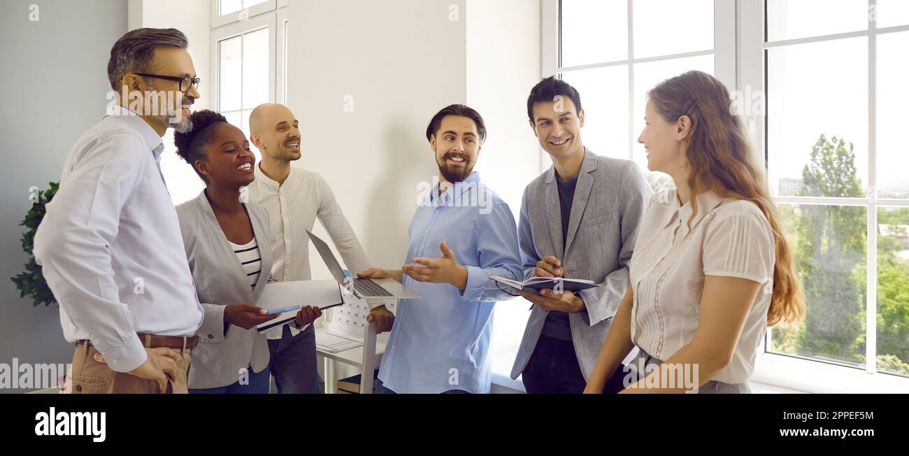 Group of office colleagues chatting and discussing work during informal ...