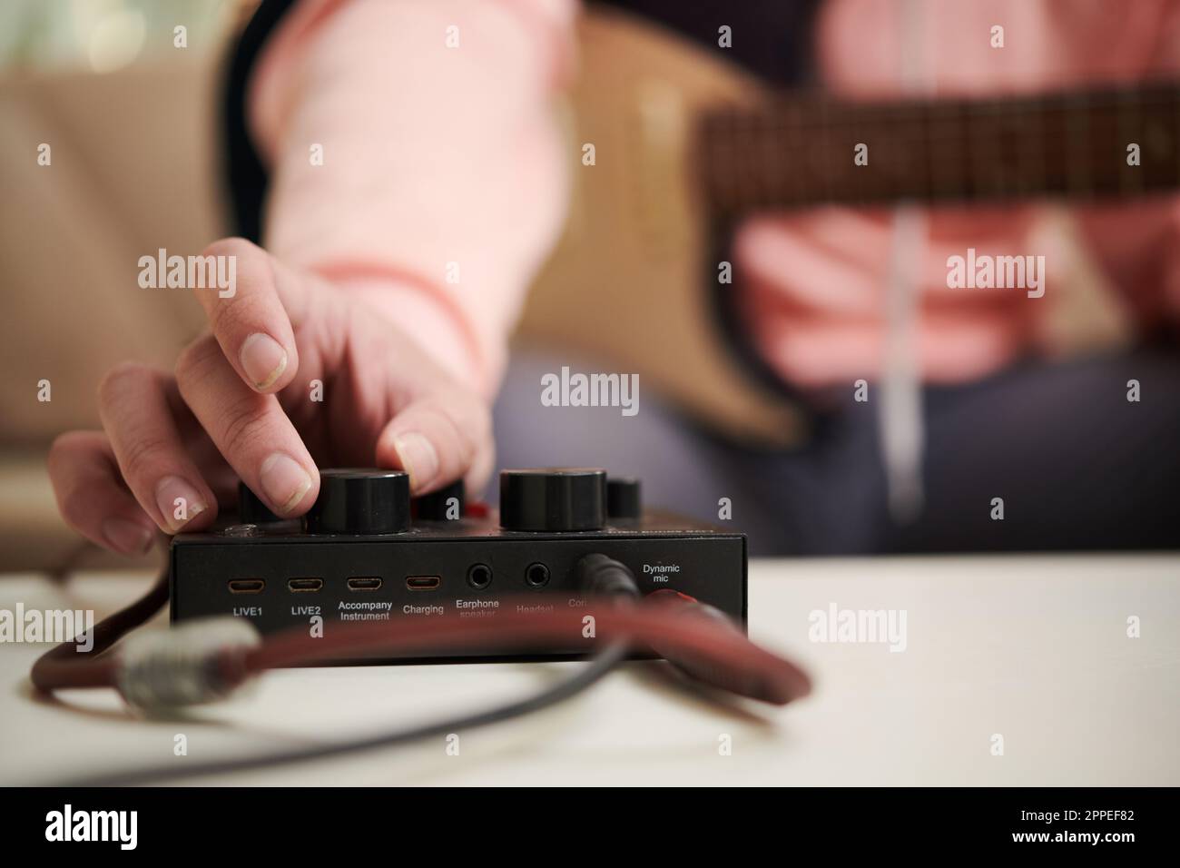 Hands of musician using amplifier to set volume level Stock Photo - Alamy