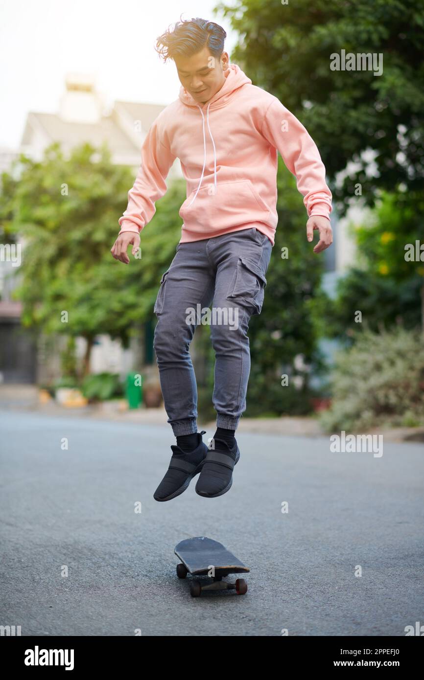 Active young man performing stunt, jumping on skateboard Stock Photo ...