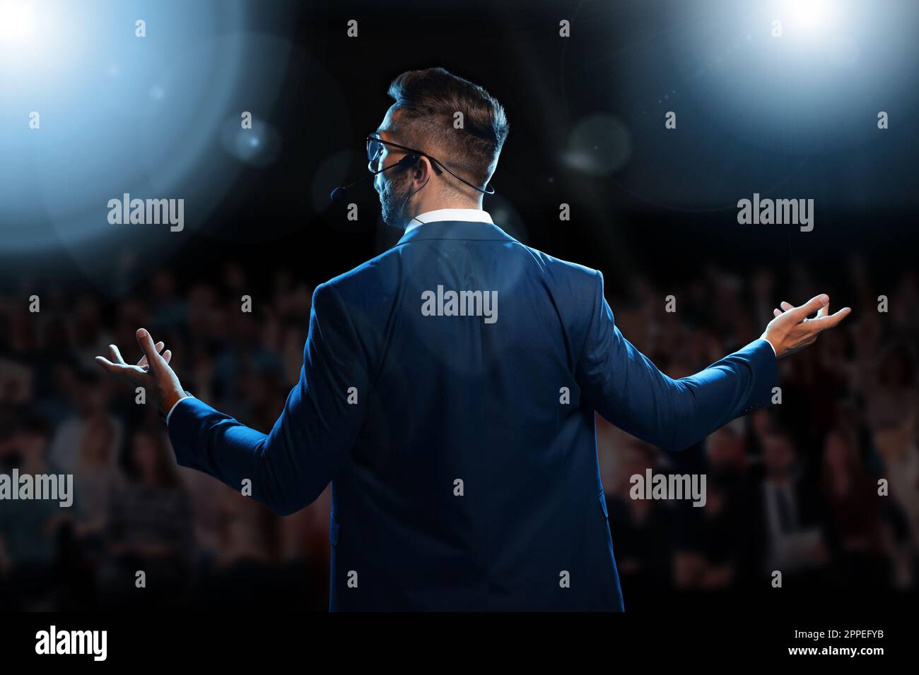 Motivational speaker with headset performing on stage, back view Stock ...