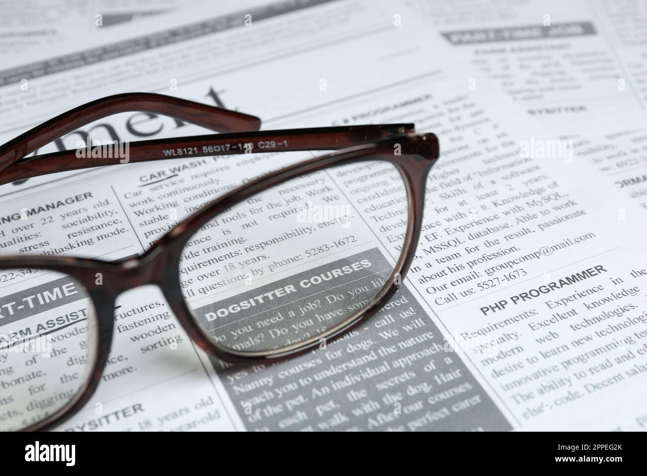 Glasses on newspaper, closeup view. Search concept Stock Photo - Alamy