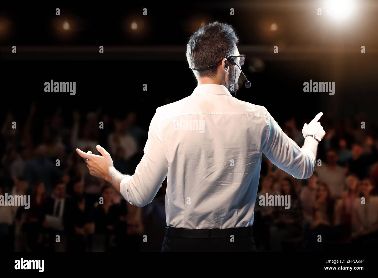 Motivational speaker with headset performing on stage, back view Stock ...