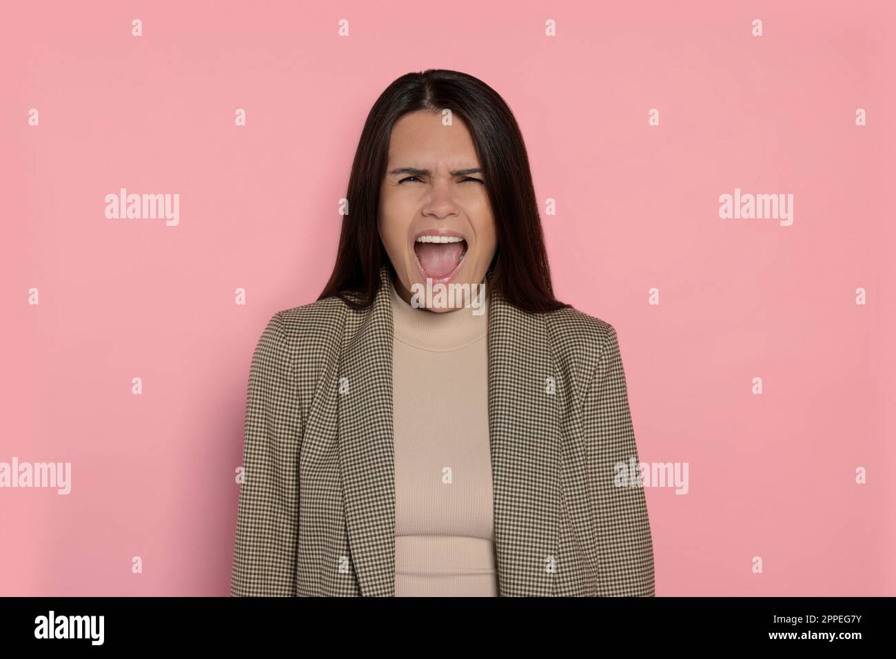 Aggressive young woman shouting on pink background Stock Photo - Alamy