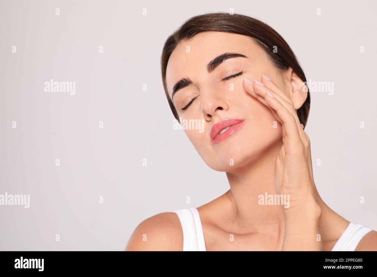 Beautiful woman with perfect skin under eyes on light background. Space ...