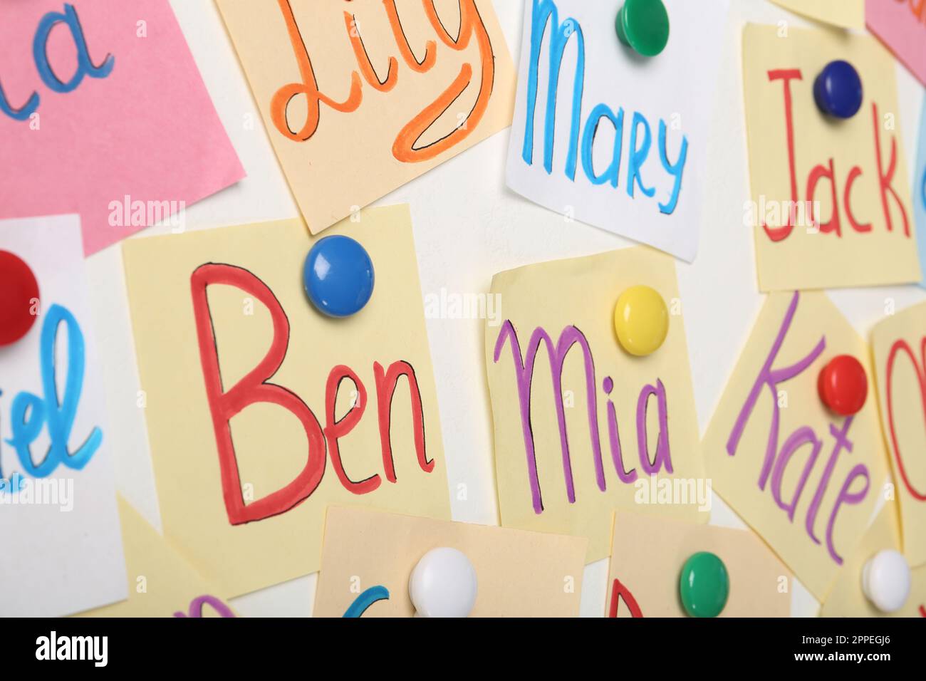Colorful paper sheets with written different baby names on white ...