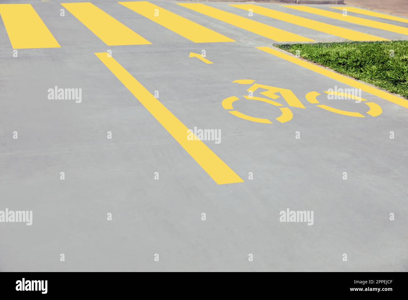 Bike lane with painted yellow bicycle sign and arrow near pedestrian ...