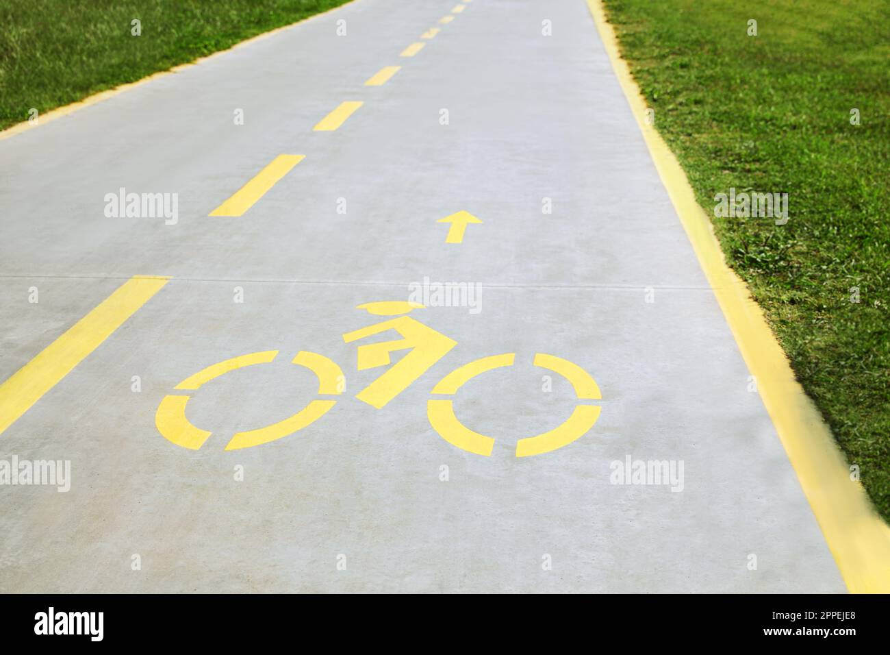 Bike lane with painted yellow bicycle sign and arrow Stock Photo - Alamy