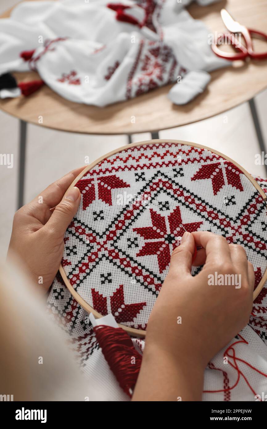 Woman embroidering white shirt with colorful threads in hoop, closeup ...