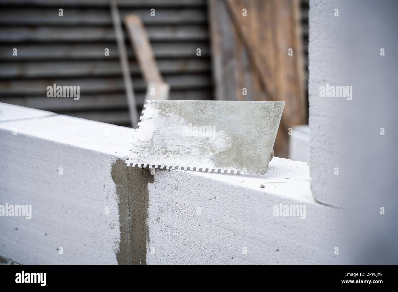 Old comb trowel at a construction site. Tool for laying gas block ...