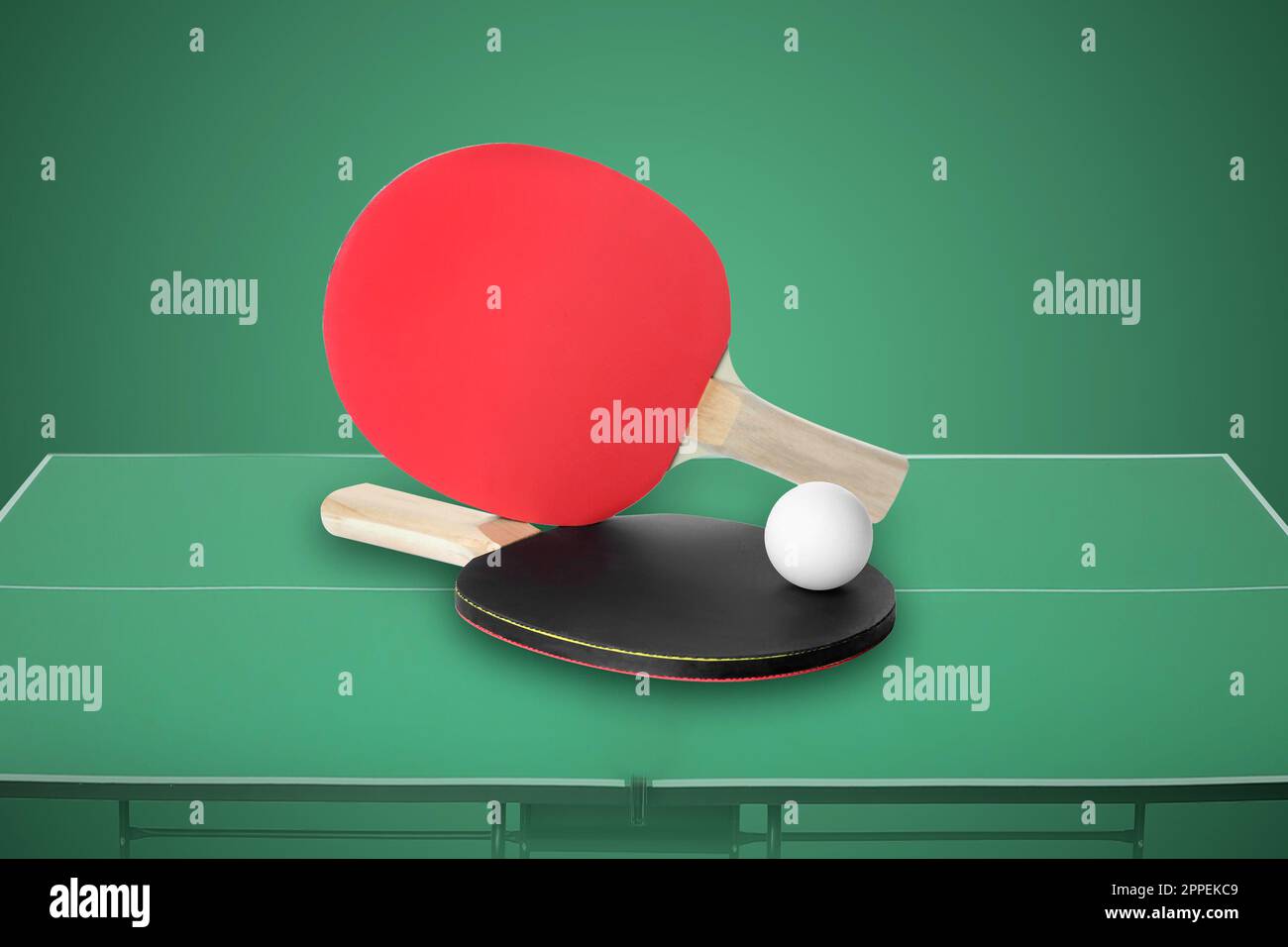 Paddles and ball on ping pong table against green background Stock ...
