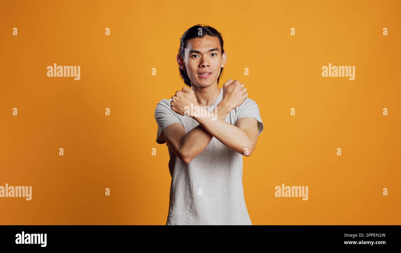 Asian person showing x shape gesture with hands, expressing refusal and ...