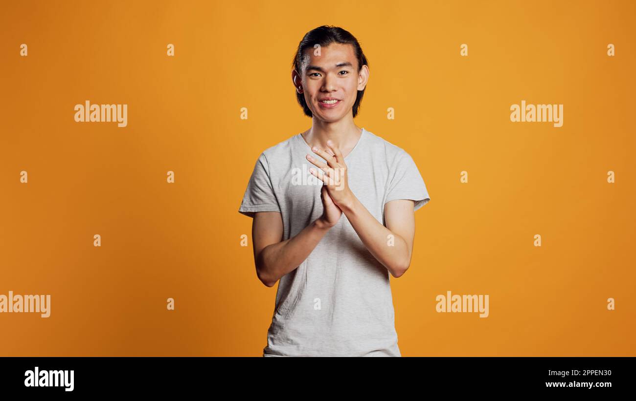 Asian man clapping hands on camera, smiling and showing positive ...