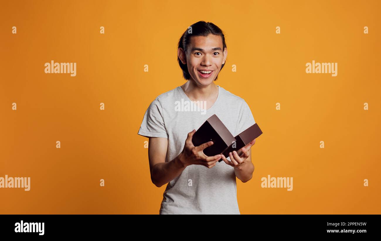 Excited male model receiving present in box, feeling happy and spoiled ...