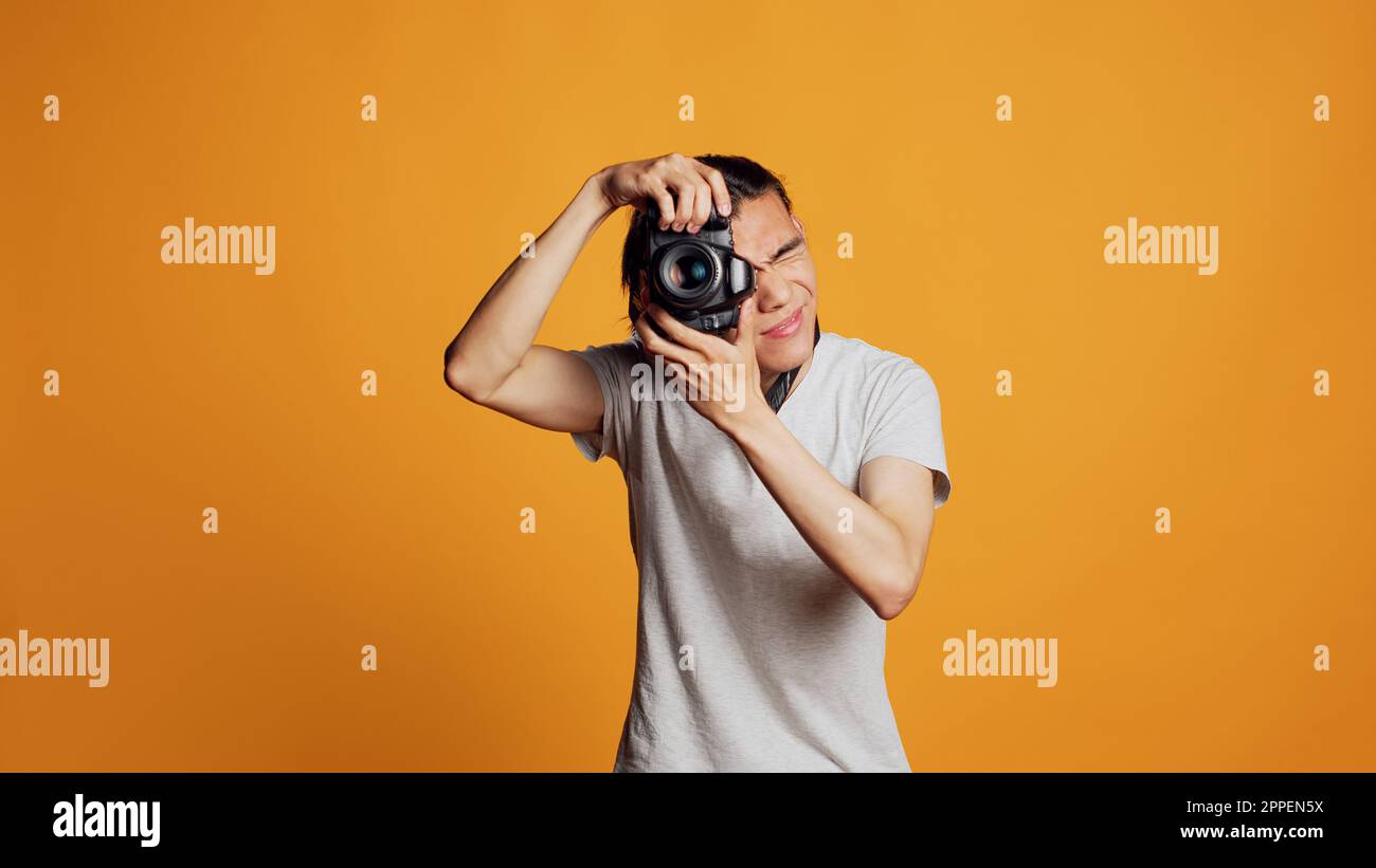Young professional photographer using dslr camera to take pictures ...