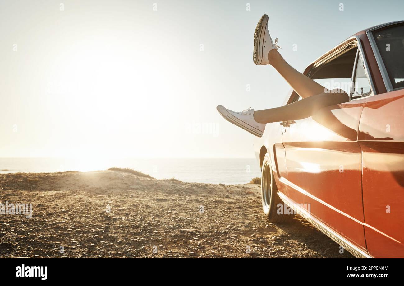 First stopfun. a womans legs hanging out a car window while on a road ...