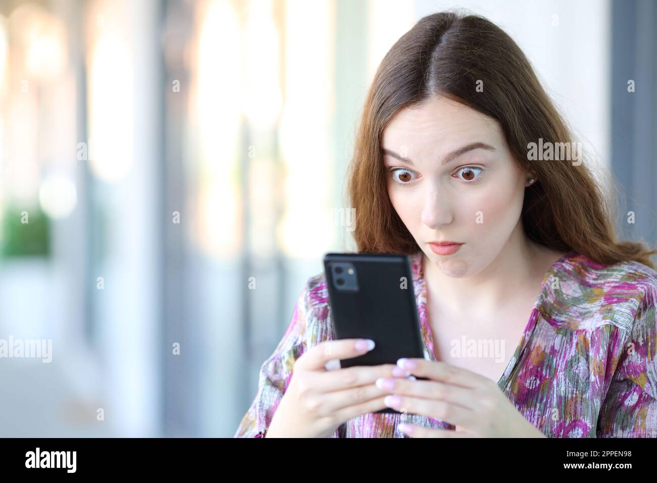 Perplexed woman checking cell phone walking in the street Stock Photo - Alamy