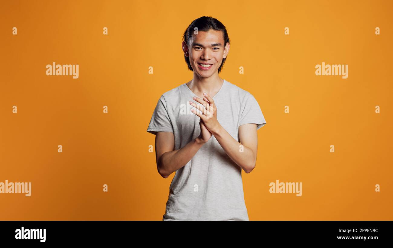 Smiling person clapping hands in studio, laughing and showing natural ...