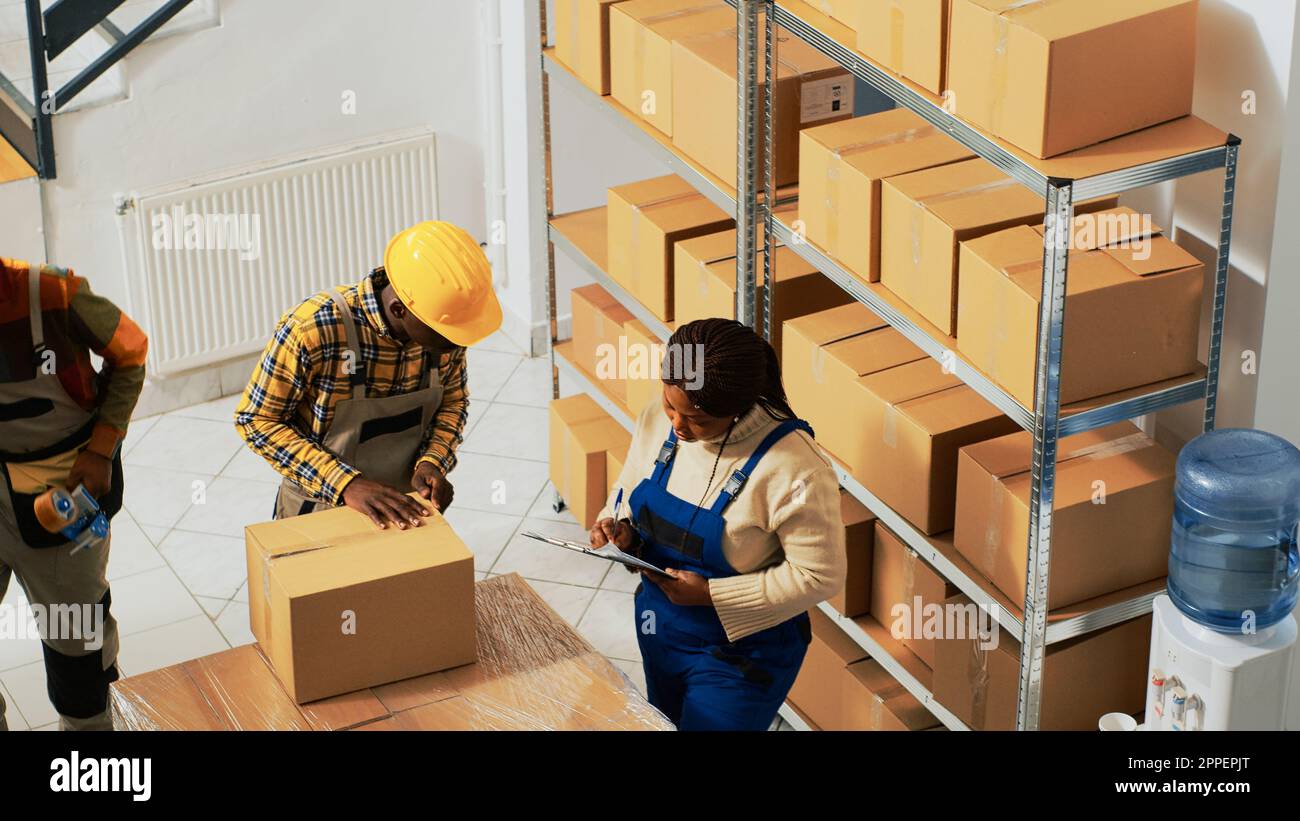 Team of depot workers taking supplies off of racks, checking retail ...