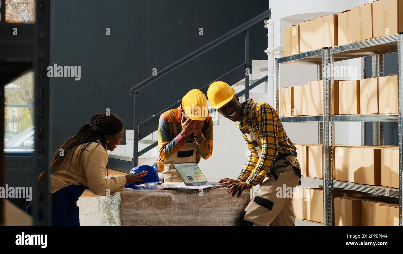 Positive people laughing and enjoying warehouse work, preparing ...