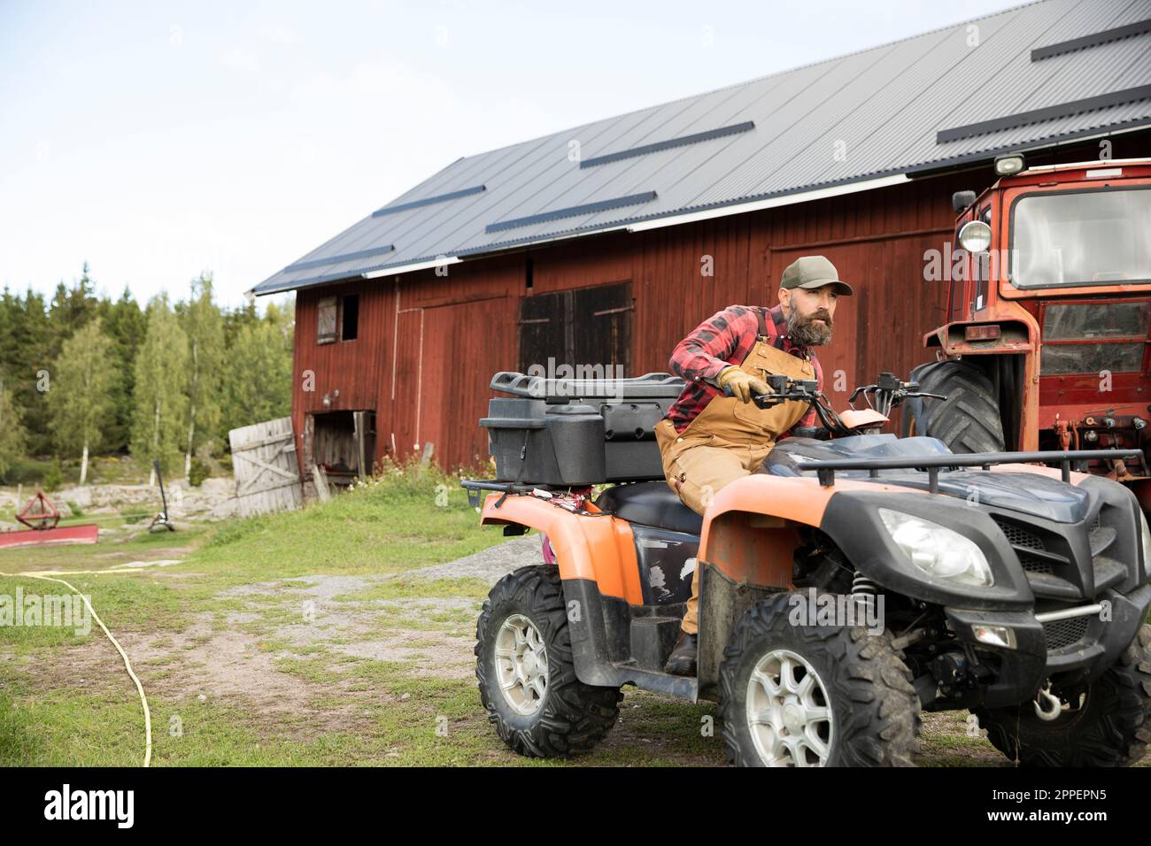 Male farmer driving four-wheeler Stock Photo - Alamy