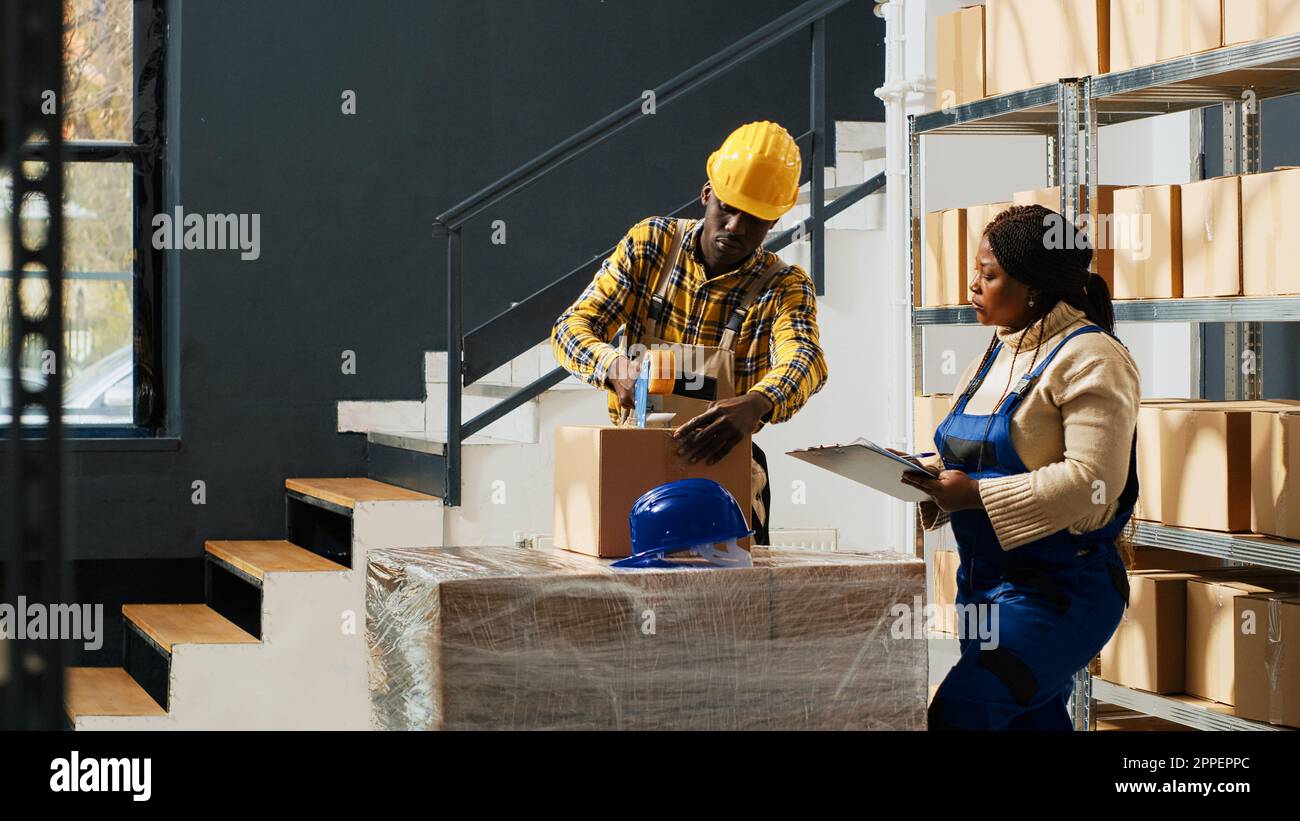 Two workers stacking boxes and working on logistics, doing quality ...