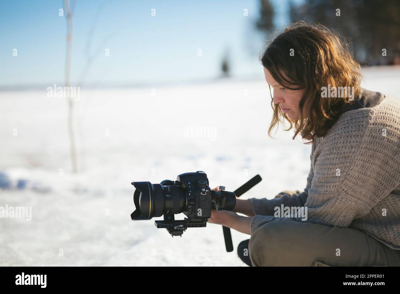 Photographer sitting on snow and relaxing Stock Photo - Alamy