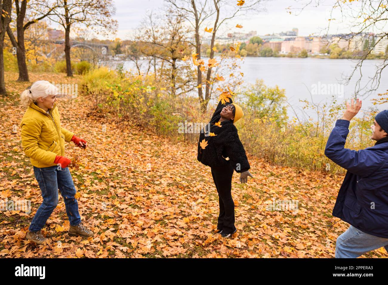 Happy young friends having autumn walk Stock Photo - Alamy