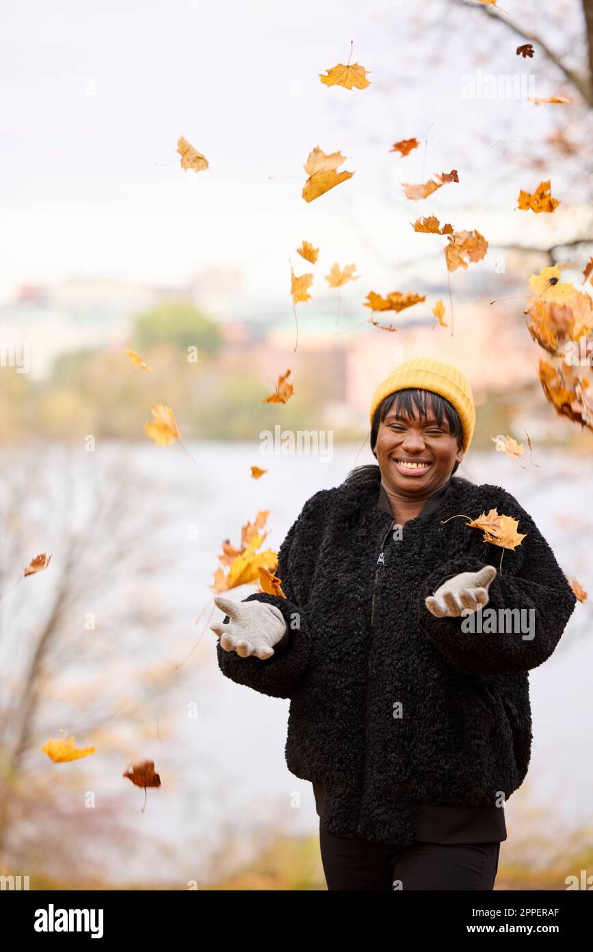 Happy woman throwing fallen leaves hi-res stock photography and images - Alamy