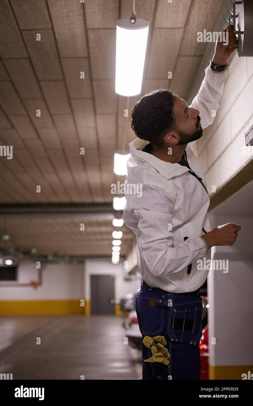 Rear view of man checking air duct Stock Photo - Alamy