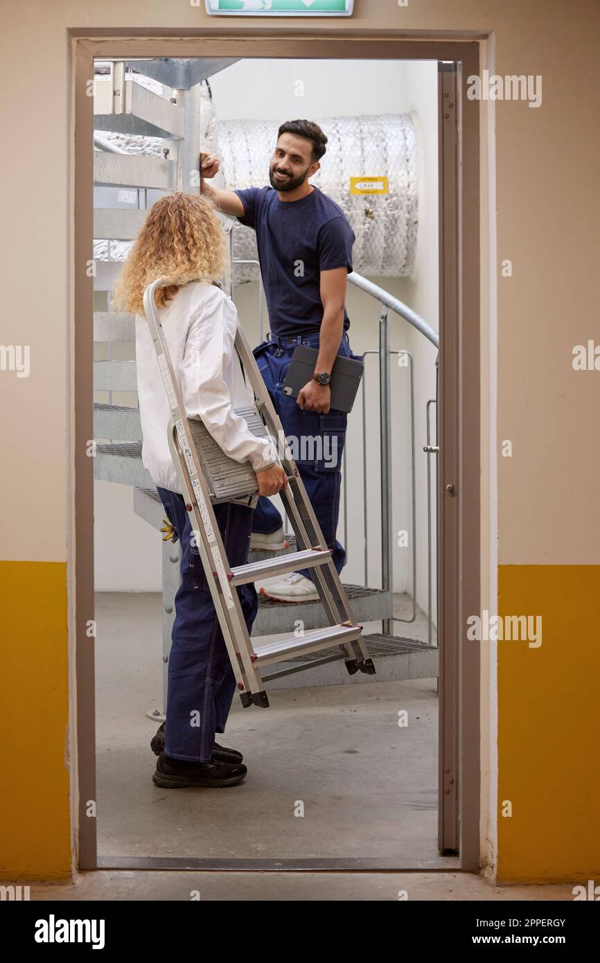 Man and woman checking air duct Stock Photo - Alamy