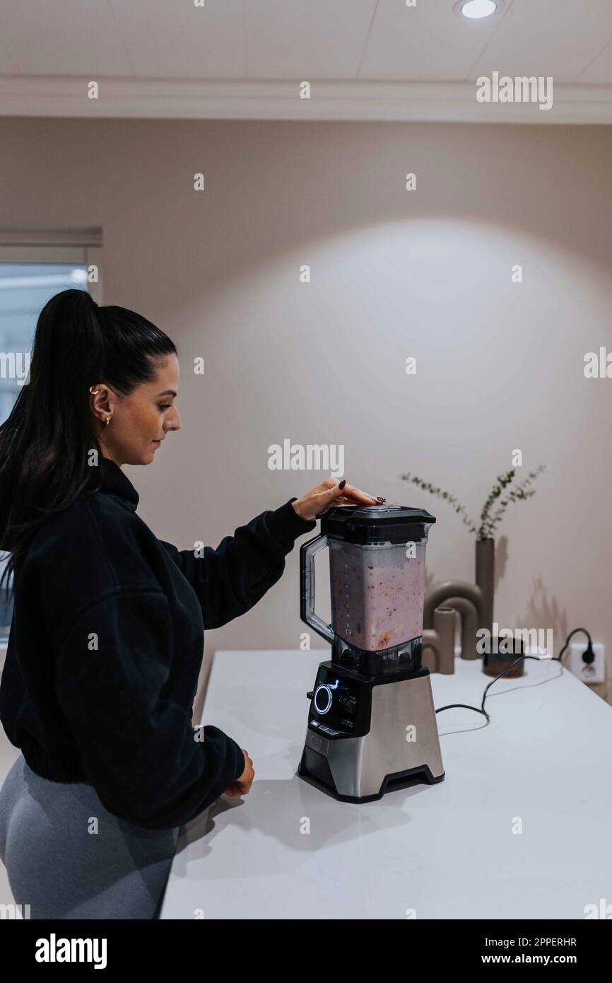 Woman using blender in kitchen Stock Photo - Alamy