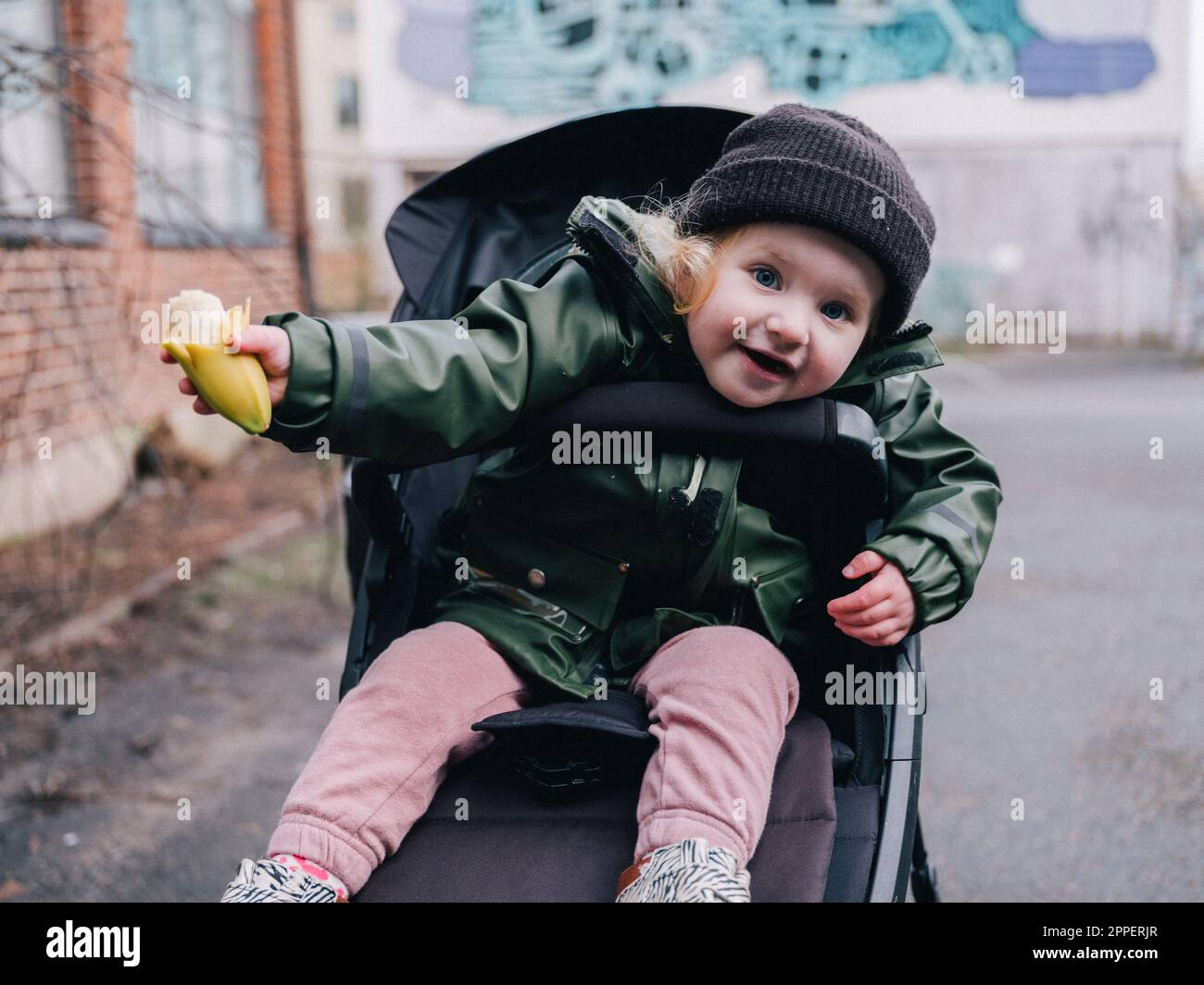 Portrait of girl sitting in stroller Stock Photo - Alamy