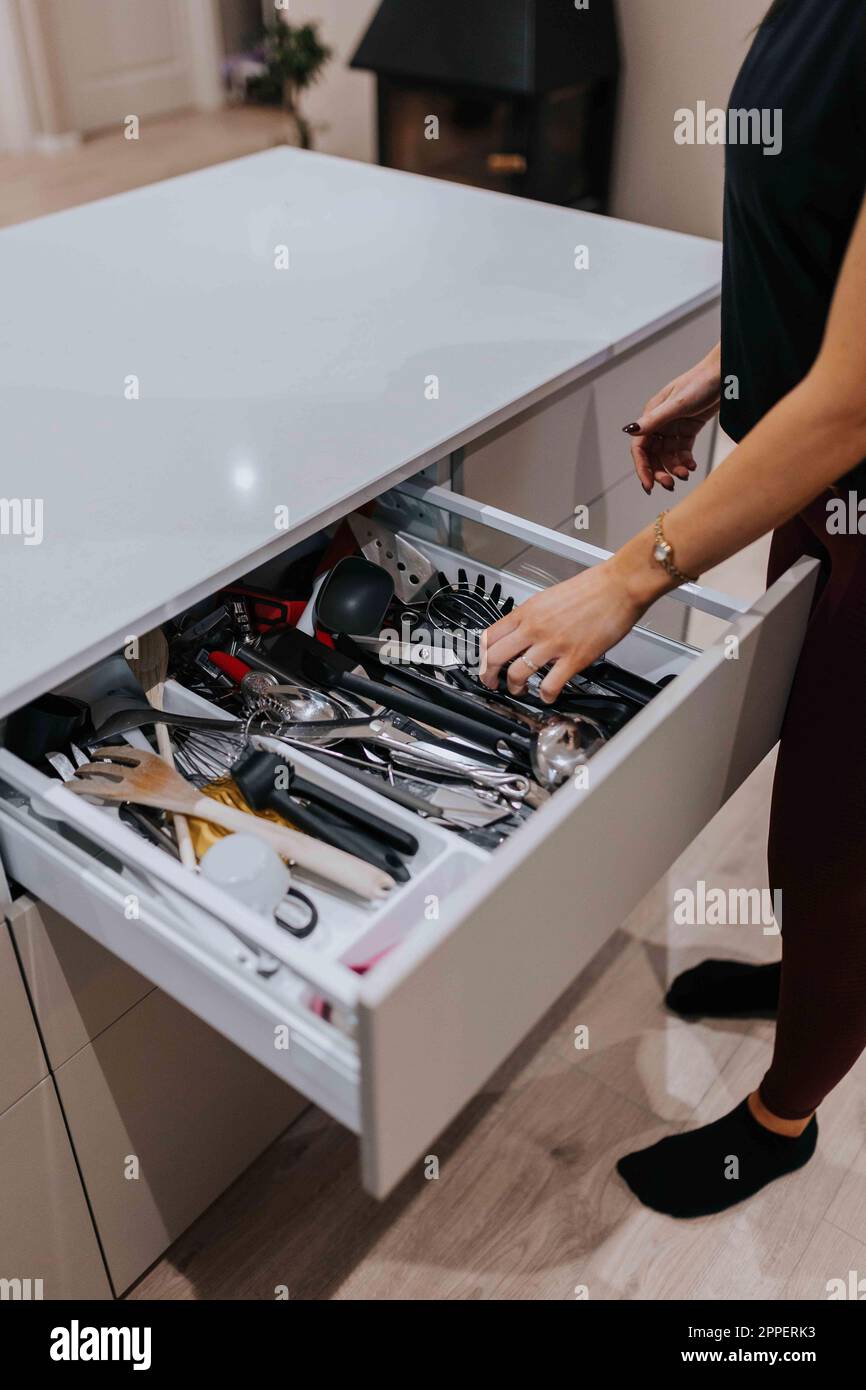 Woman's hand in open kitchen drawer Stock Photo - Alamy