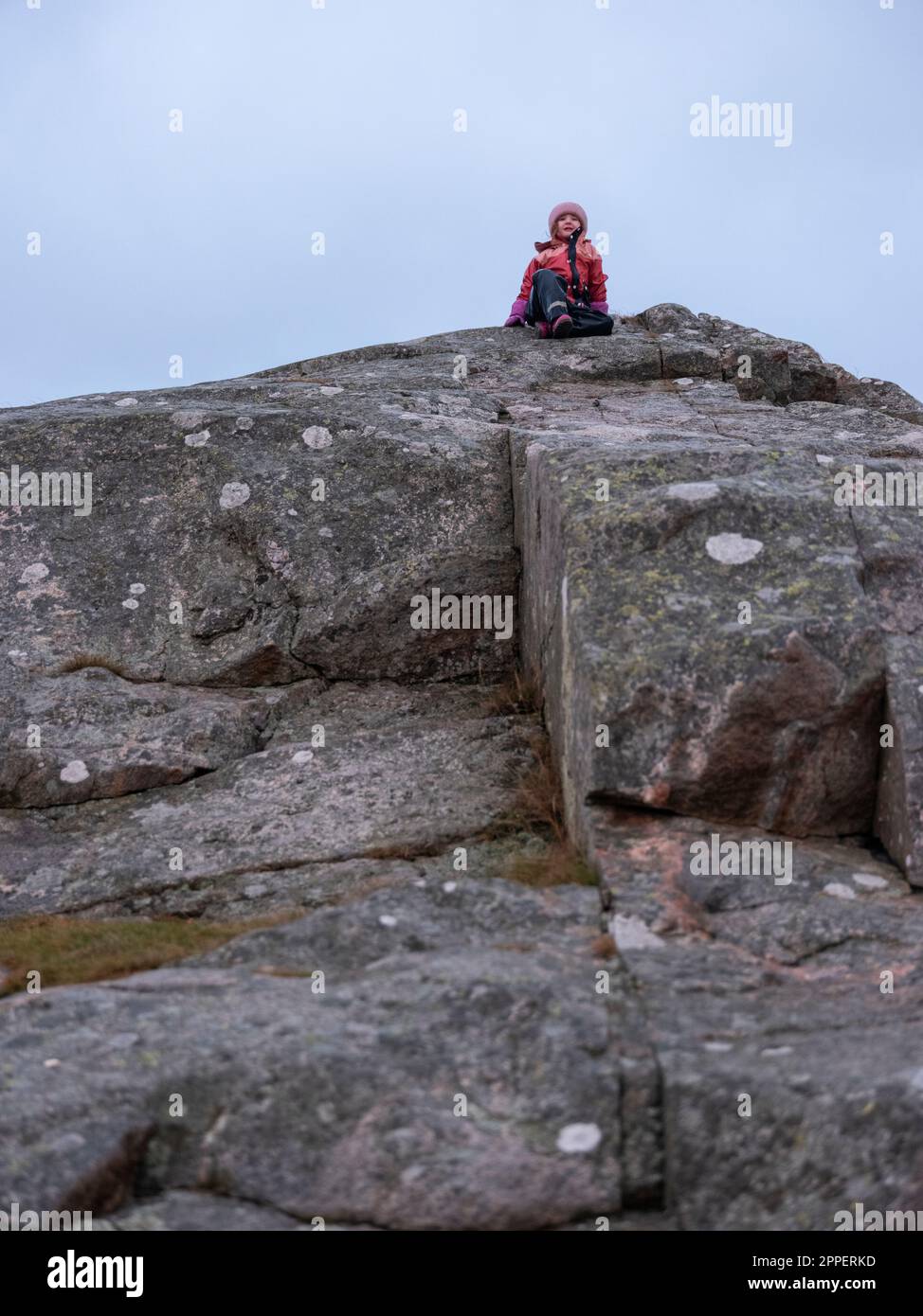 Child sitting on top of rock Stock Photo - Alamy