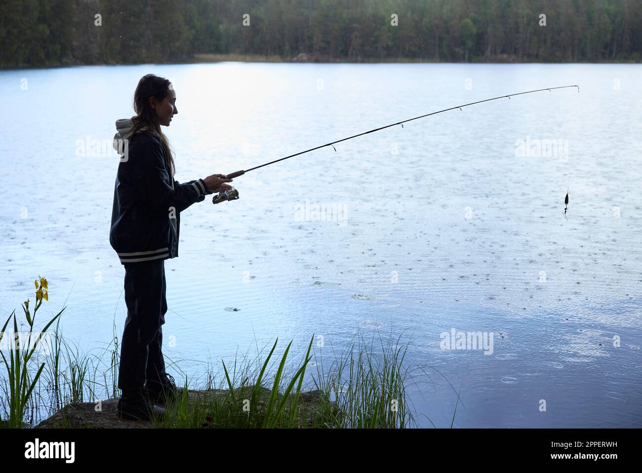 Side view of woman fishing at lake Stock Photo - Alamy
