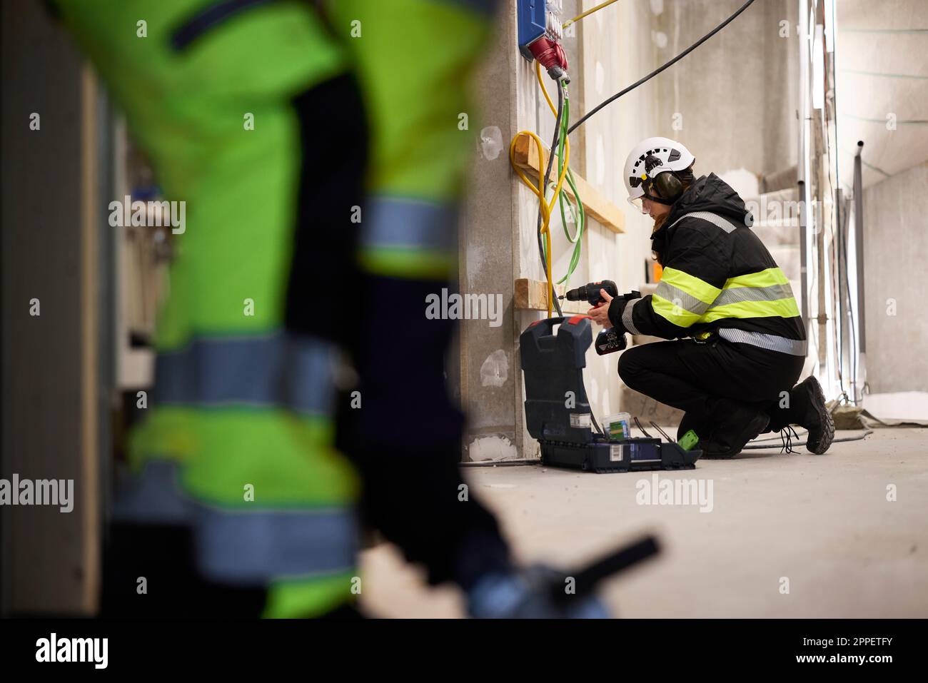 Construction worker using electric drill Stock Photo - Alamy