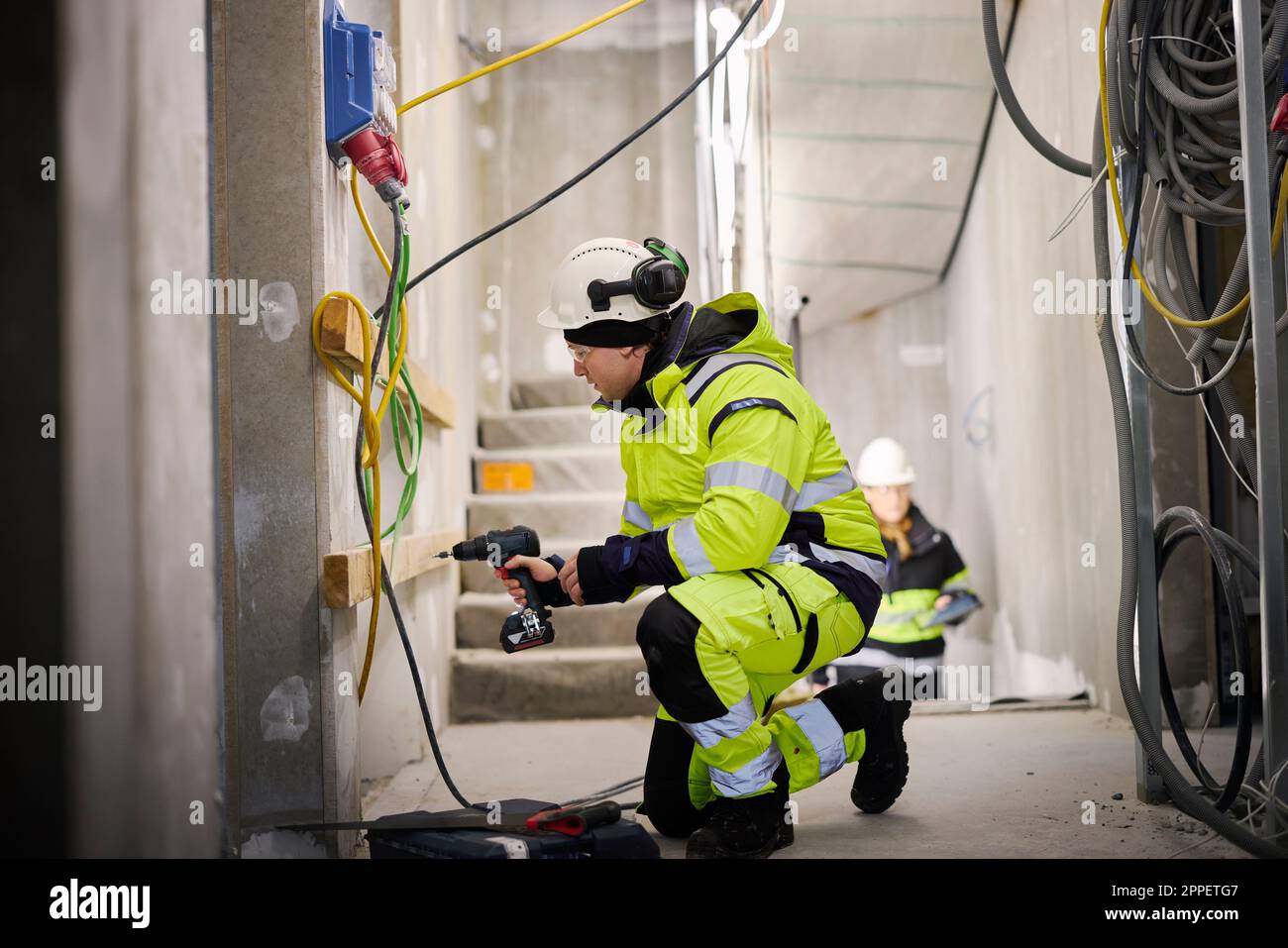 Construction worker using electric drill Stock Photo - Alamy